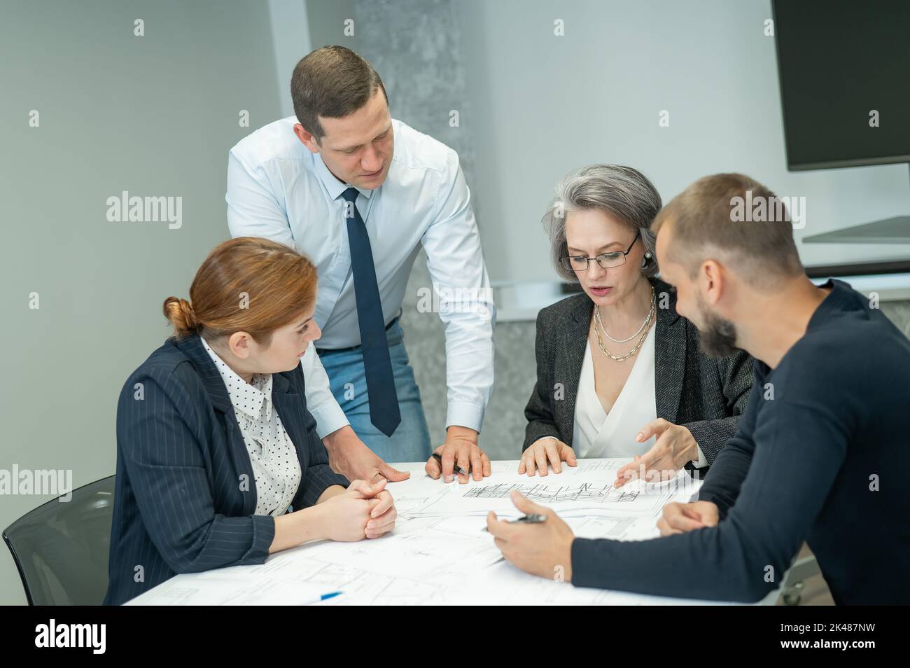 The boss gives instructions to three employees in the office conference ...