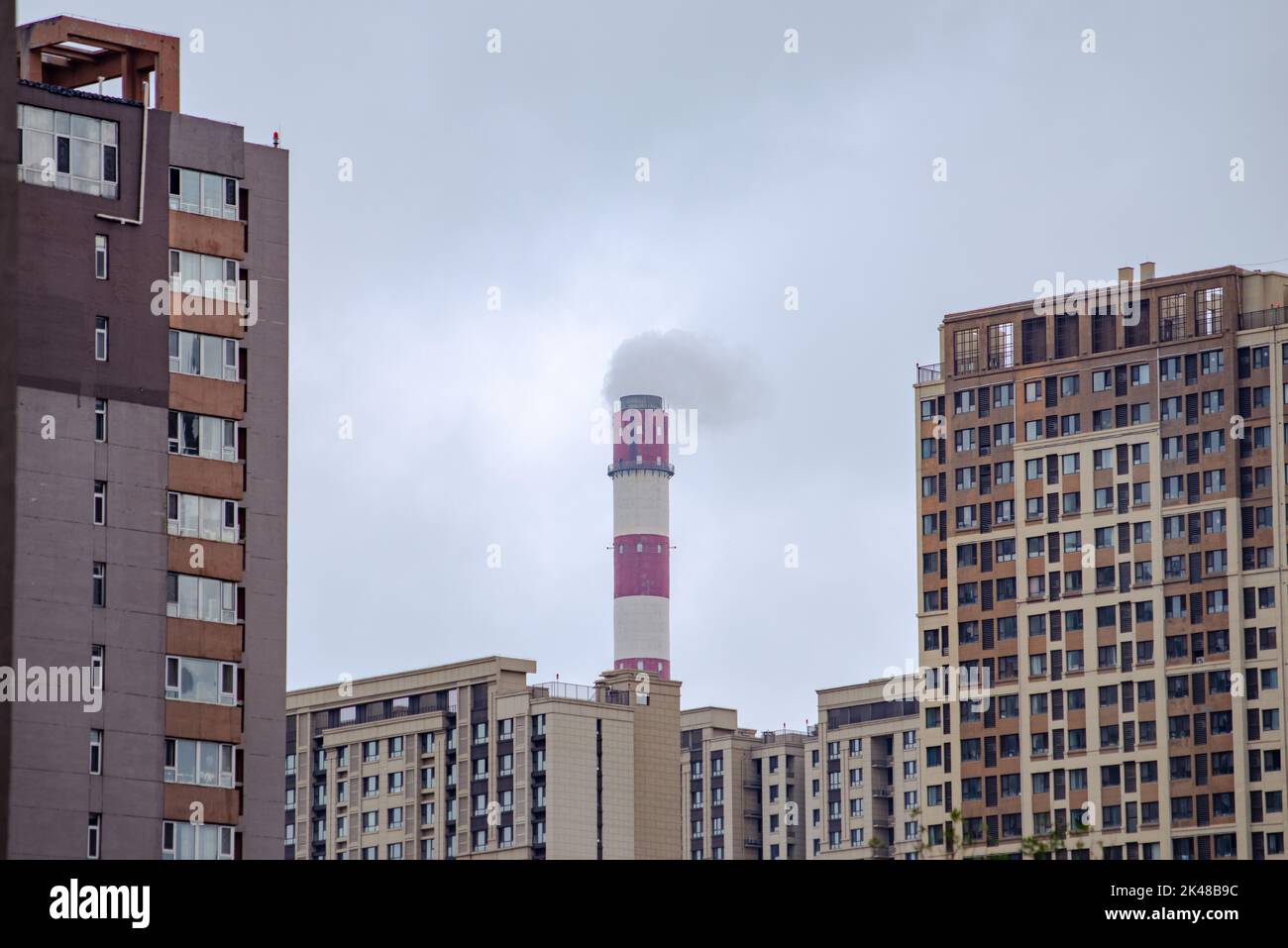 buildings in the city. Smoke coming out from chimneys and touching the ...