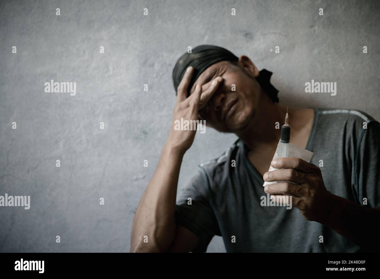 Stop drug addiction concept. A human hand holding a needle for heroin ...