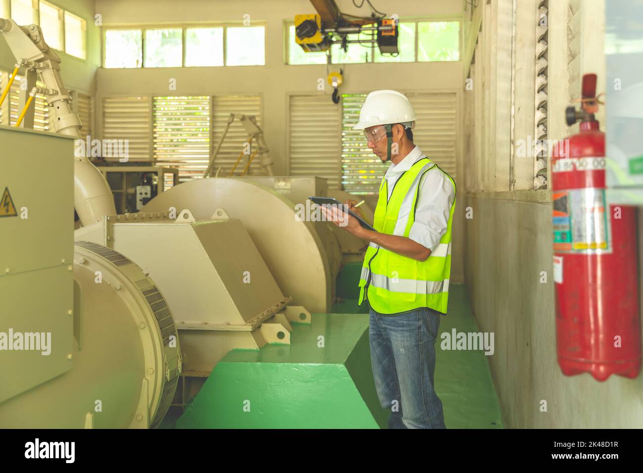 Male Superyacht Engineer working on the engine room, inspecting the ...