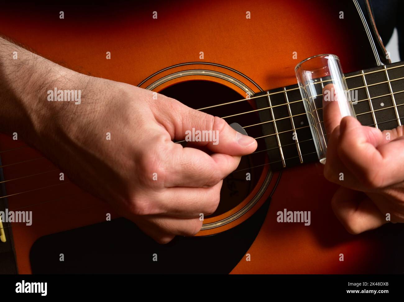 Man playing an acoustic guitar with a glass slide. Hands close-up Stock ...