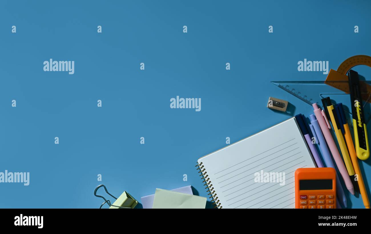 Flat lay school stationery on blue background with empty copy space ...
