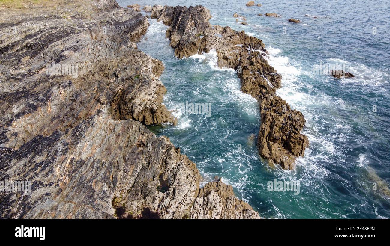 Beautiful waves break on the rocks. White foam on turquoise water ...