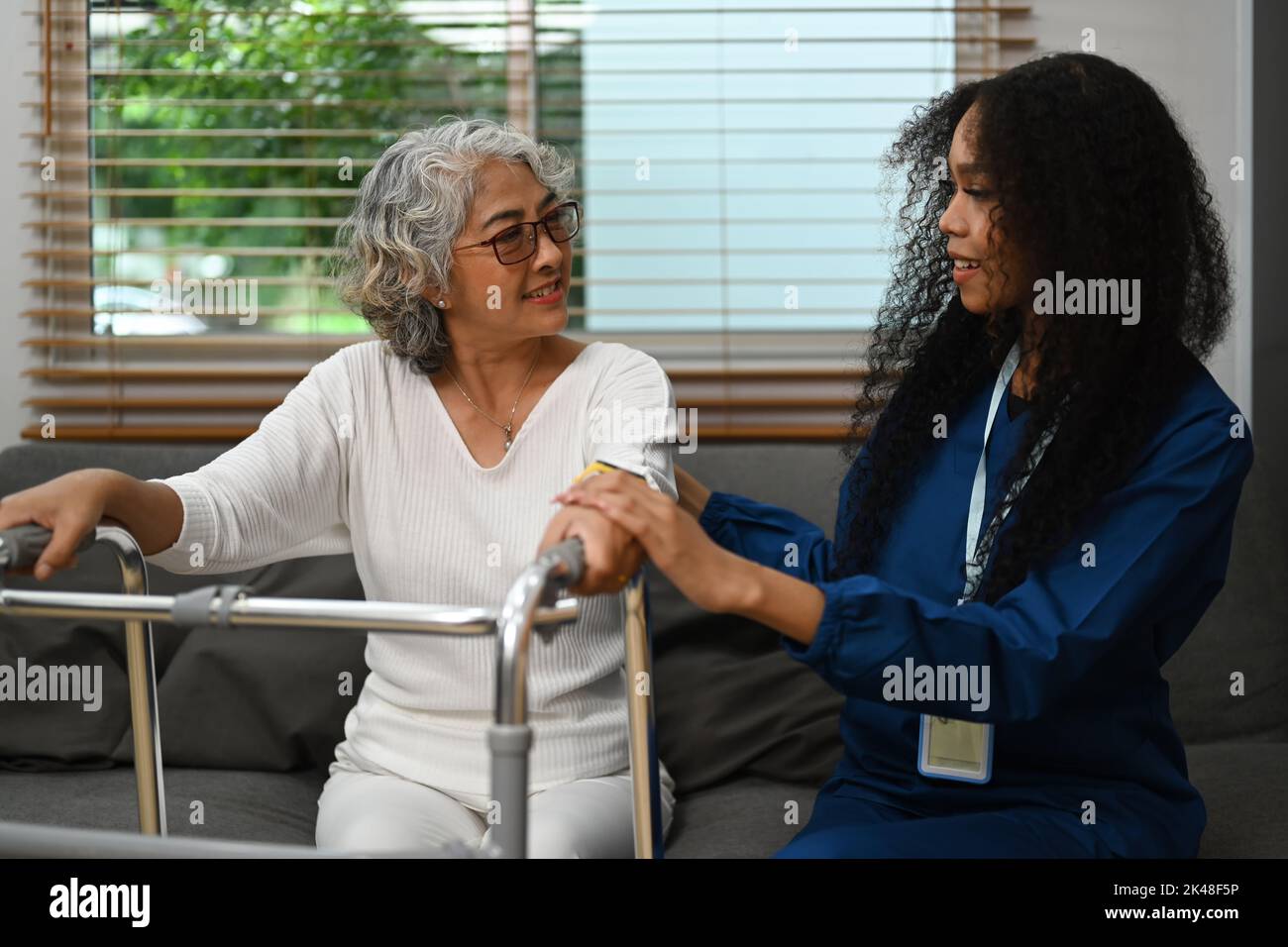Health visitor talking, giving advice to elderly woman during home ...