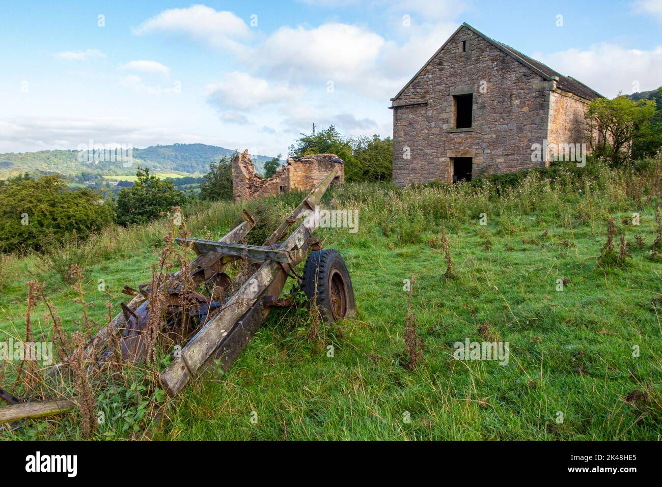 Abandoned farm building and vehicle early on a misty morning in the ...