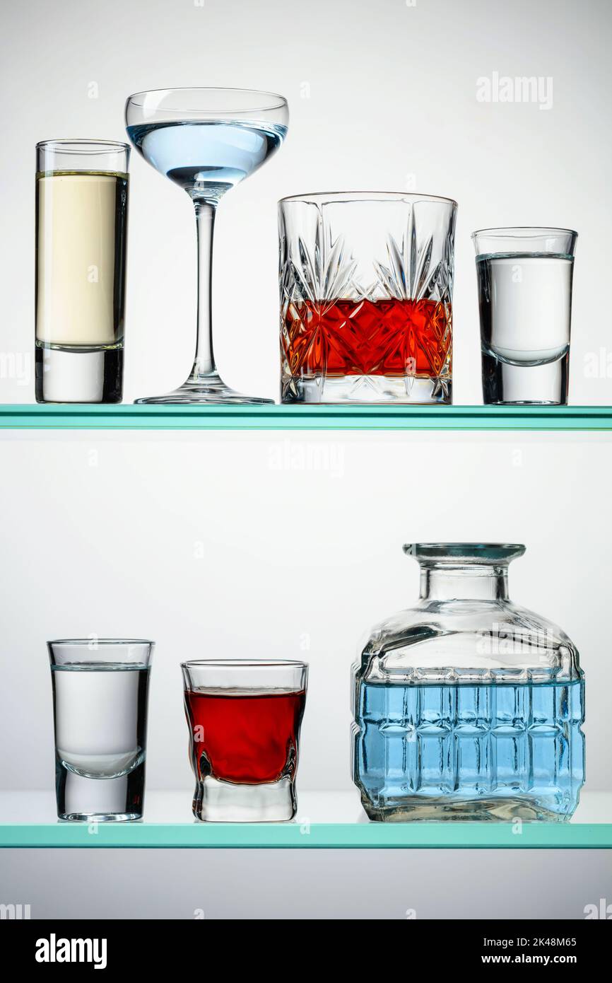 Various alcoholic drinks in the bar on glass shelves Stock Photo - Alamy