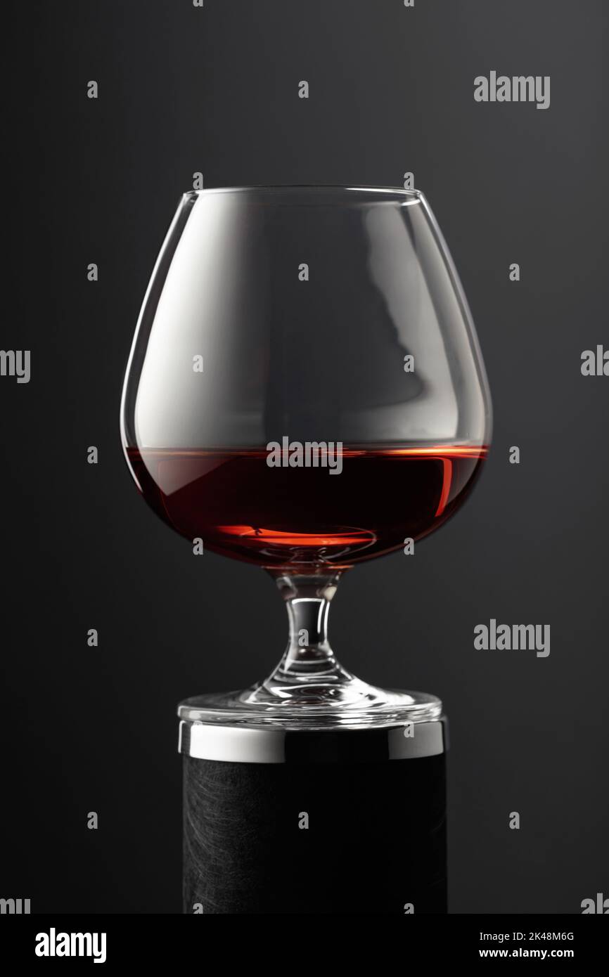 Glass of brandy on a black background Stock Photo - Alamy