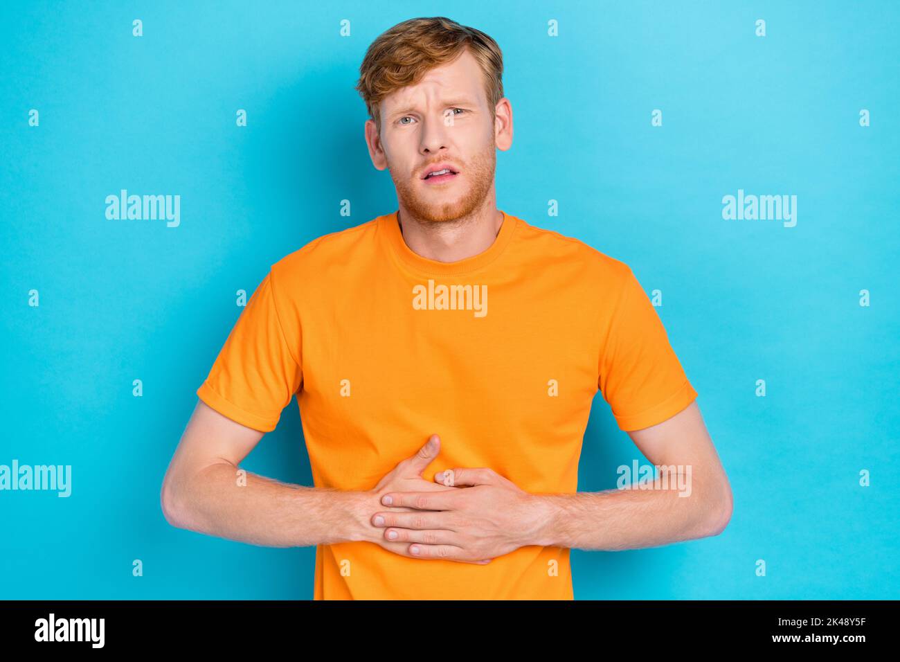 Photo of sick ginger hair guy stomachache wear orange t-shirt isolated ...