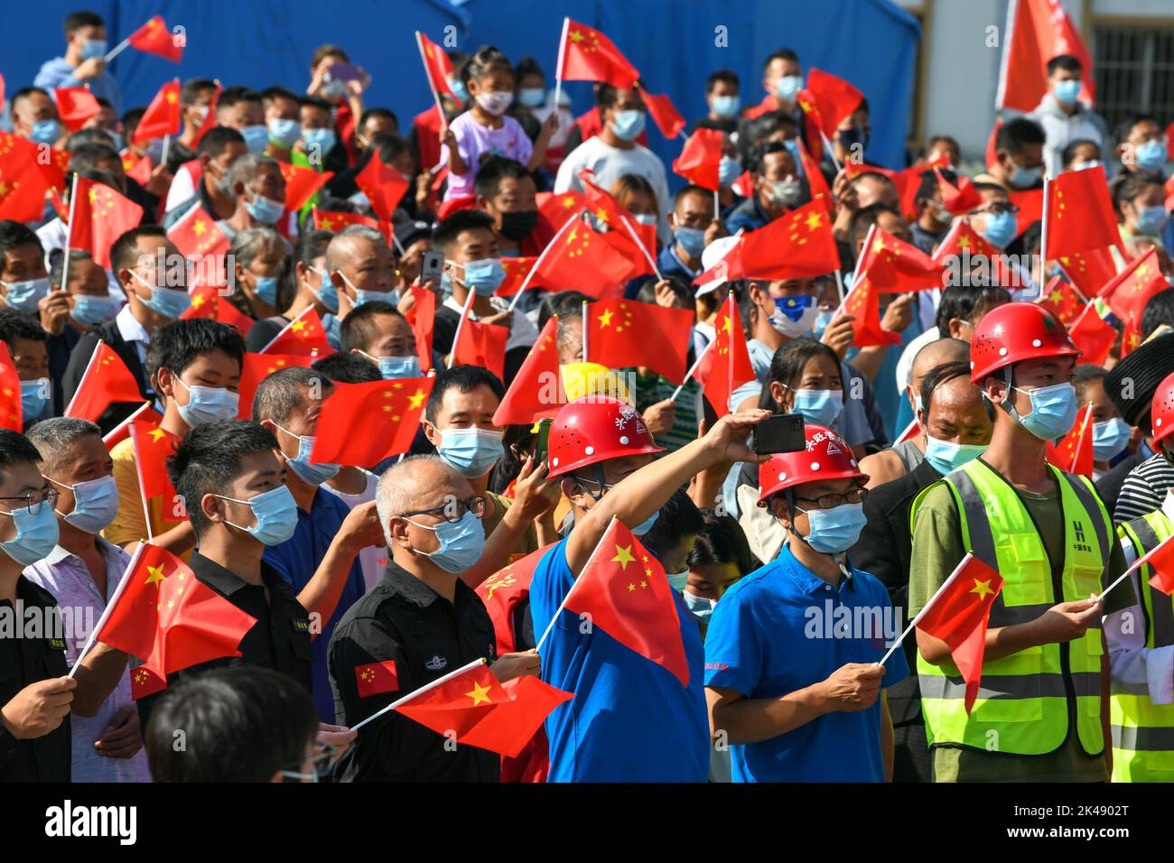 Luding, China's Sichuan Province. 1st Oct, 2022. People attend a flag ...