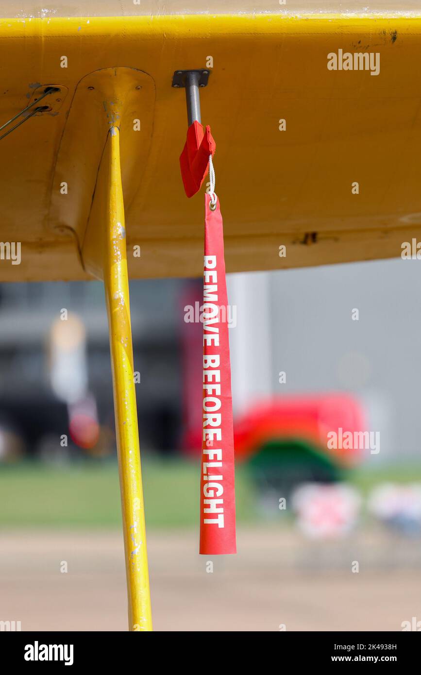Remove before flight ribbon on plane hanging from wing Stock Photo - Alamy