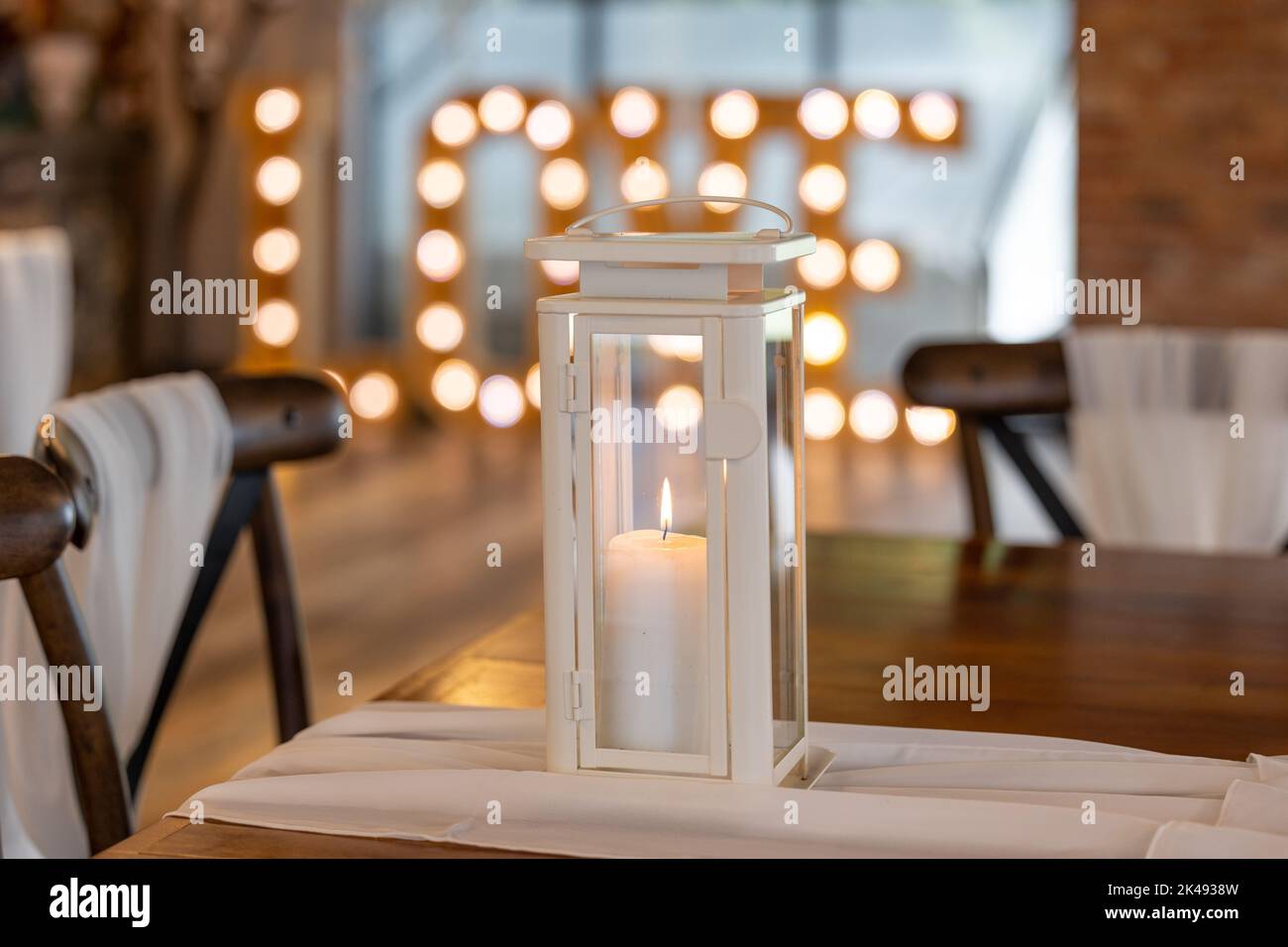 Beautiful wax real candle burning in romantic wedding venue setting ...