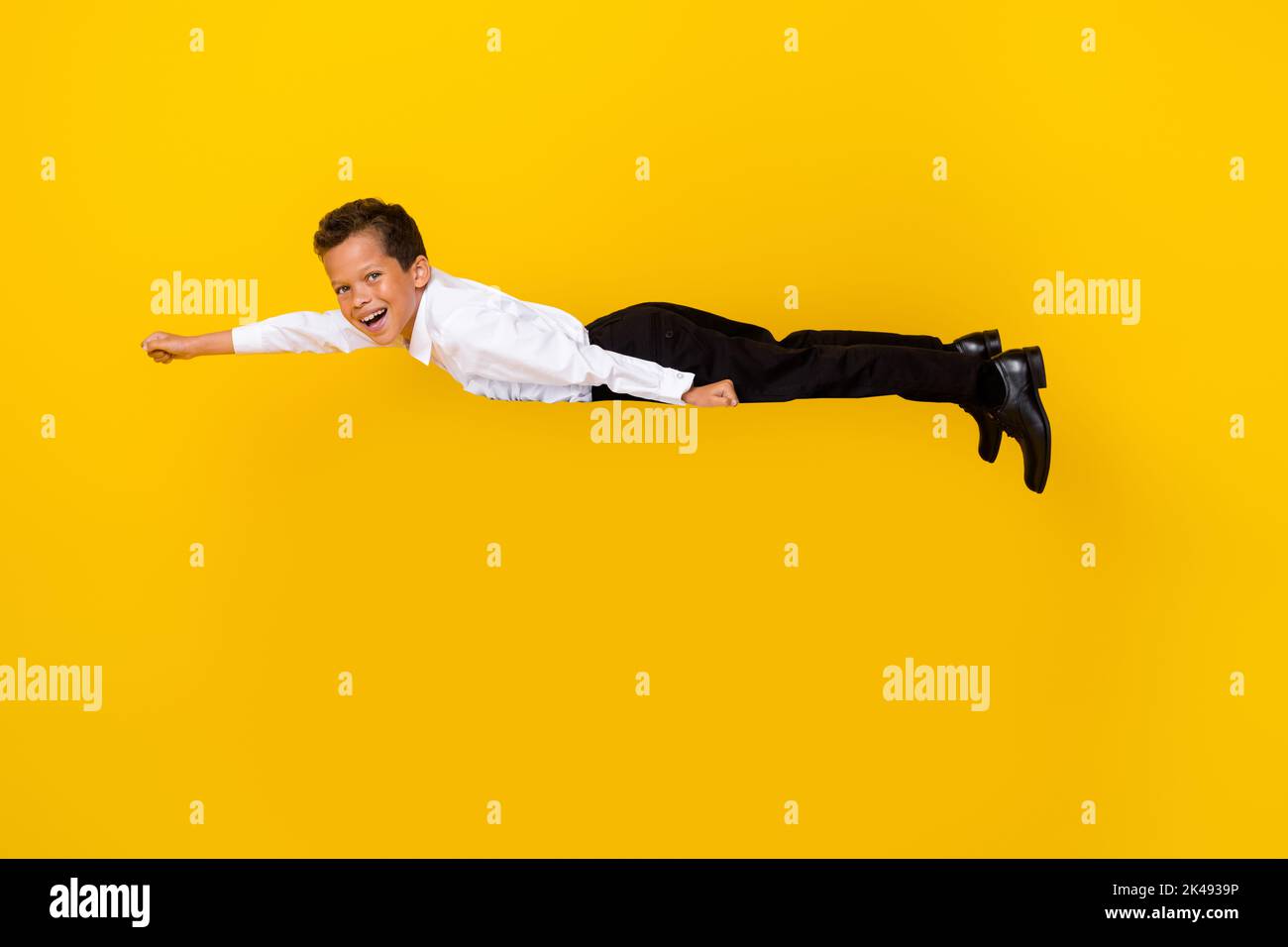 Full length profile photo of energetic cheerful boy flying empty space ...