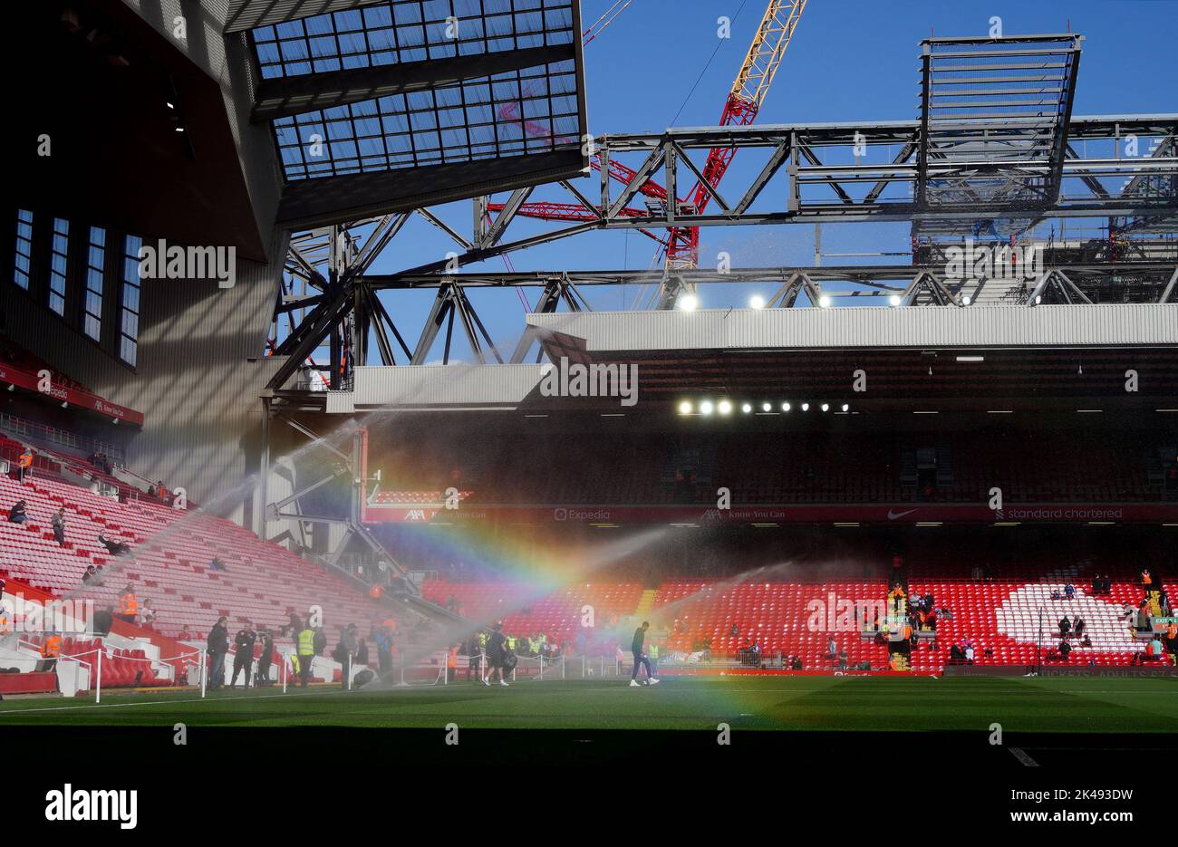 A rainbow is seen refracted from the water of a sprinkler before the ...