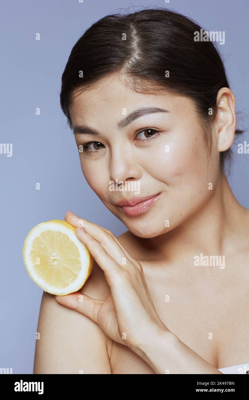 modern woman with lemon against blue background Stock Photo - Alamy