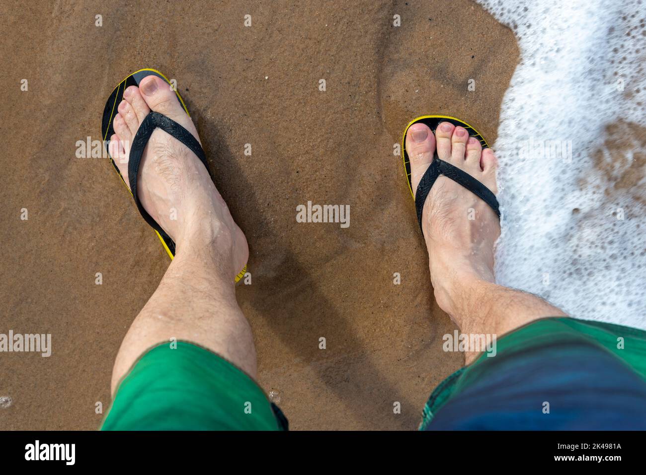 Top to bottom view of feet on the beach sand. Barra beach lighthouse ...