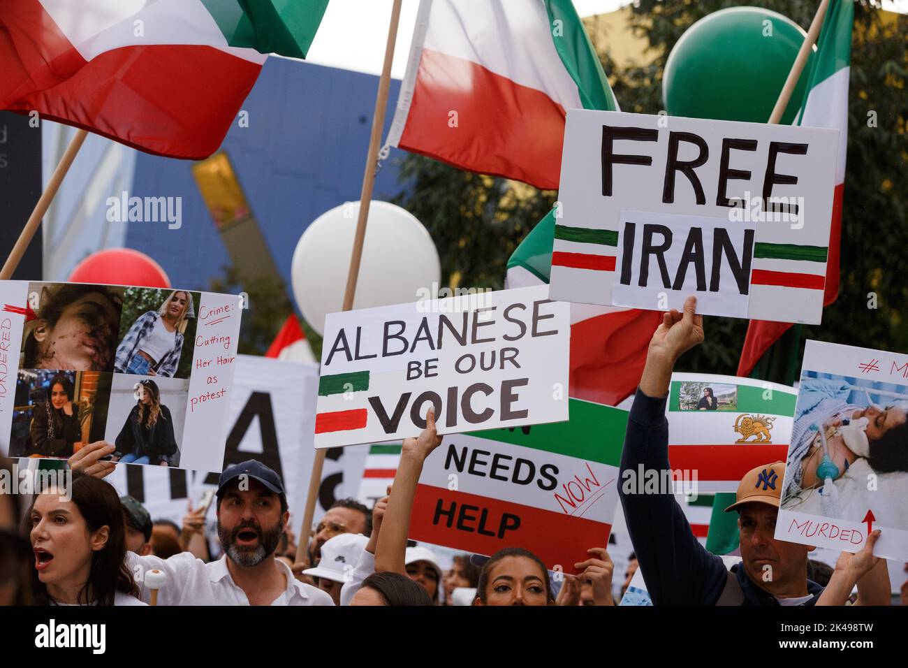 Protesters hold placards and Iranian flags during a rally calling for ...