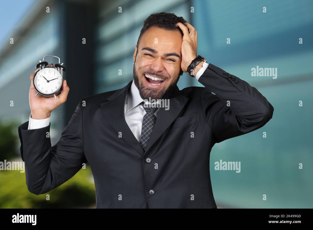 Black businessman with alarm clock. Time management concept Stock Photo ...