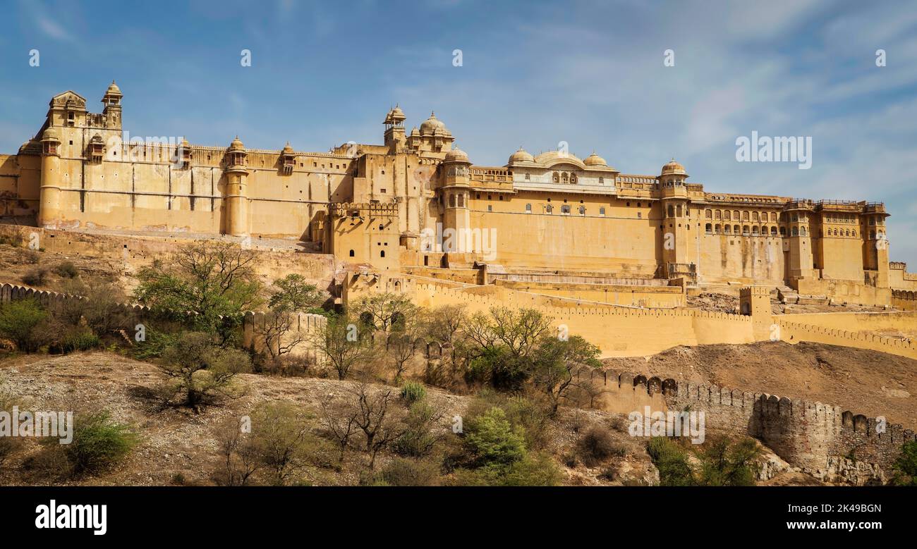 Amber Fort illuminated by warm light of the rising sun and reflected in ...