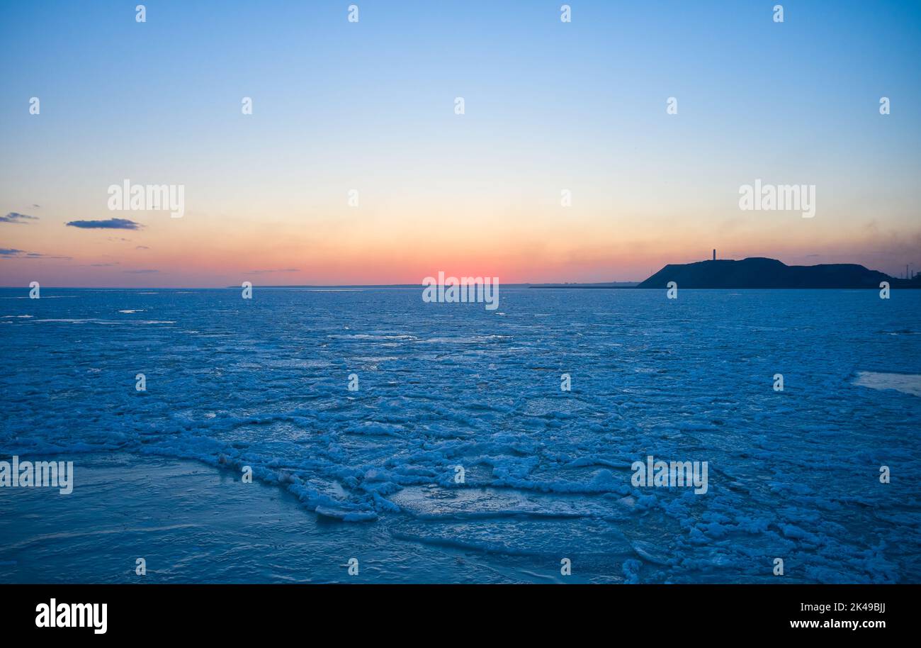 Aerial view of sunset over the frozen sea. Winter landscape on seashore ...