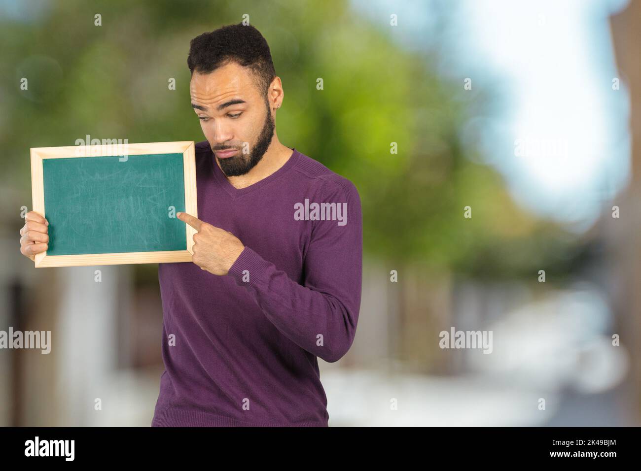Positive dark skinned male points at copy space isolated Stock Photo ...