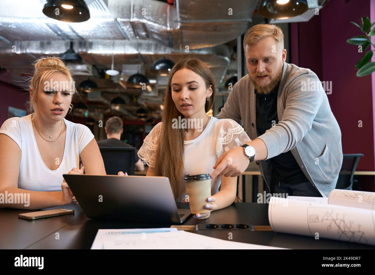 Architectural team working at new construction drawing on laptop Stock ...