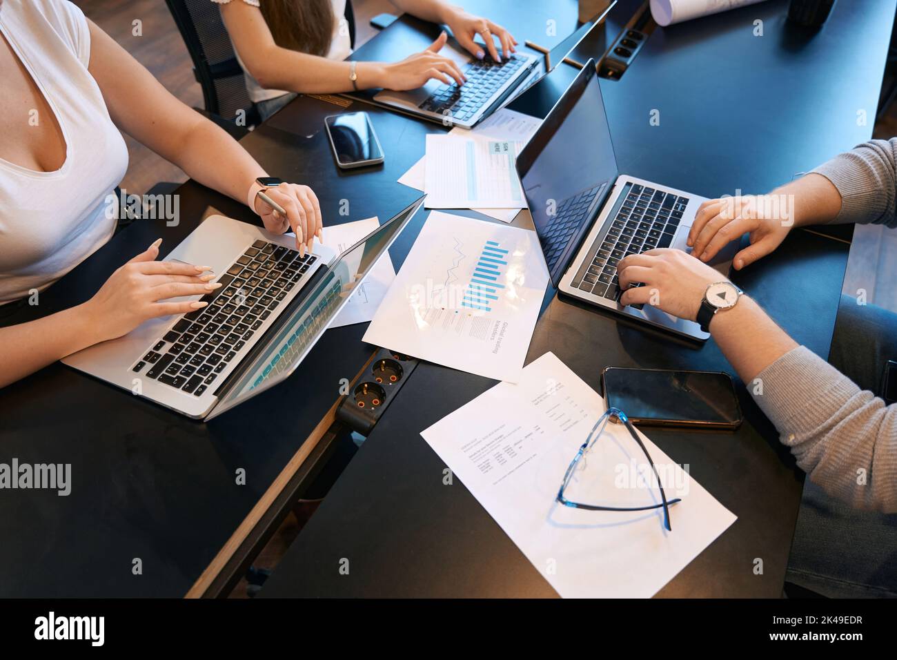Corporate workers typing on laptops at business meeting Stock Photo - Alamy