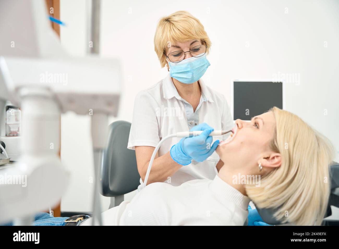 Caucasian woman doctor treats her patient's teeth Stock Photo - Alamy