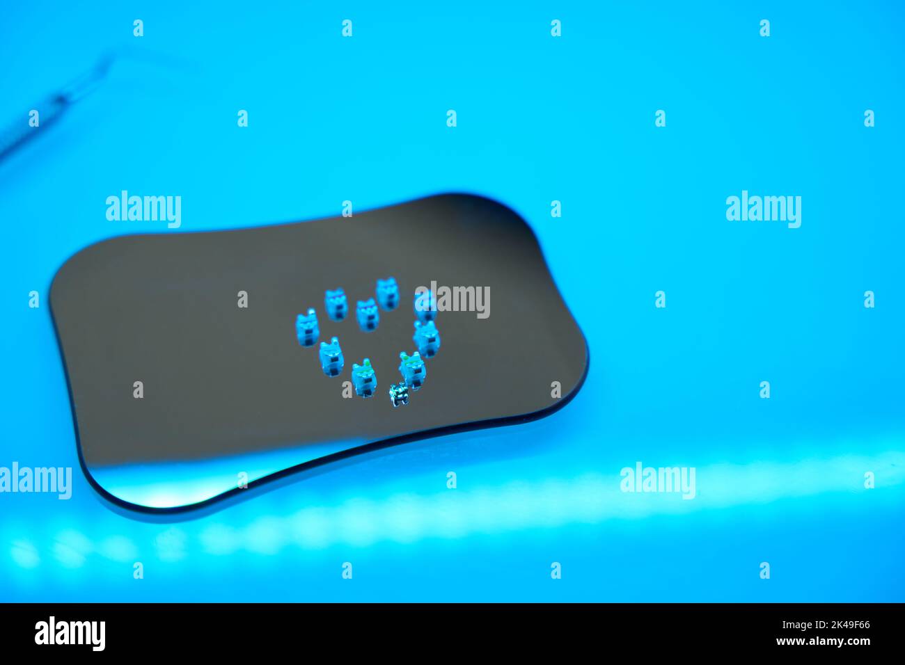 Heart-shaped ceramic sapphire braces on black stand. Modern dental ...