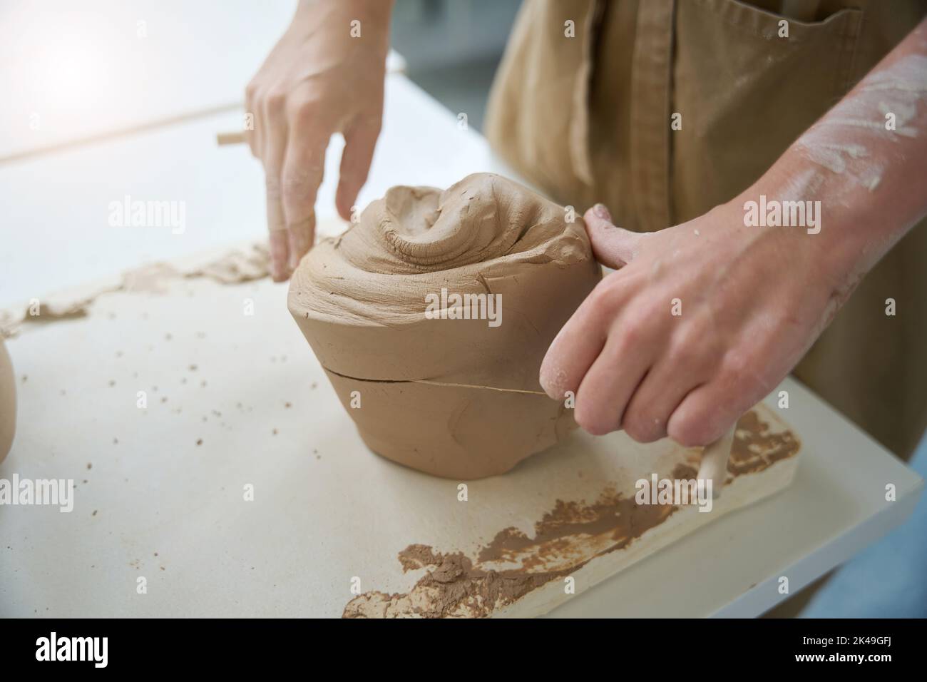 Master cuts a piece of clay with a metal string Stock Photo - Alamy