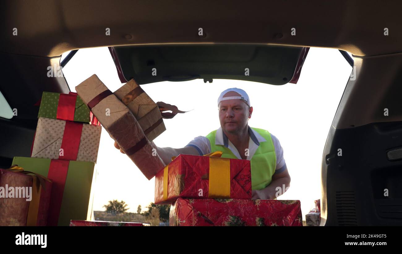 delivery service. deliveryman in protective mask. courier unloads boxes ...