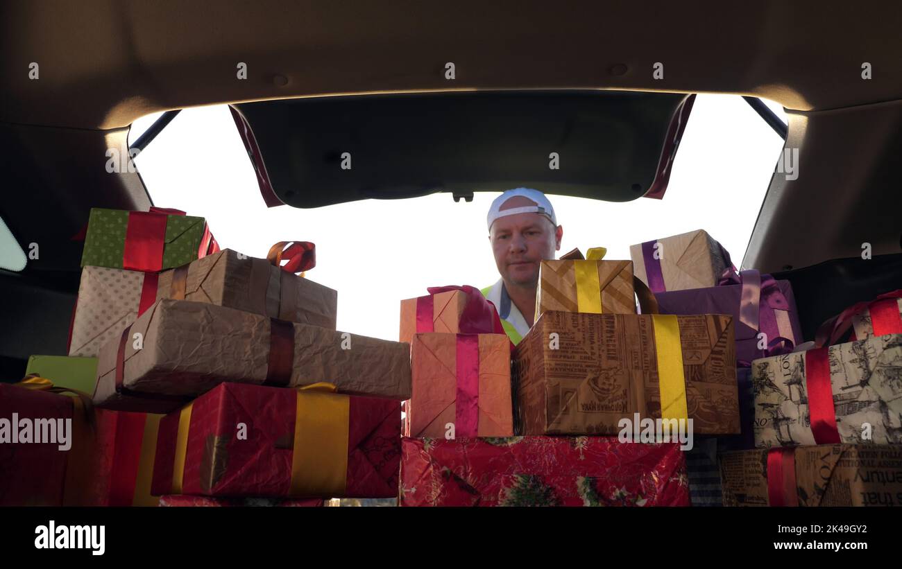 delivery service. deliveryman unloads boxes. gift boxes in car ...