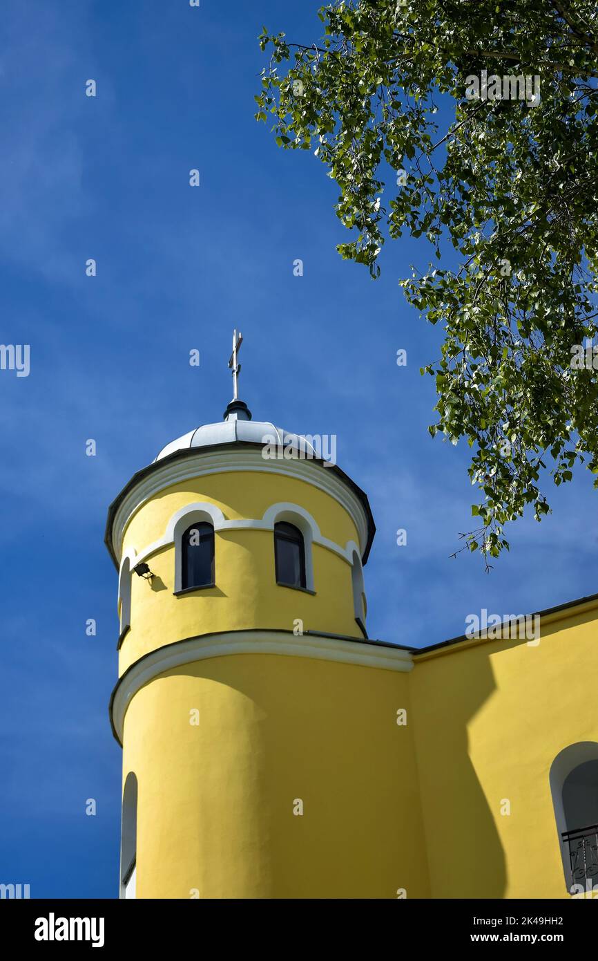 View from below of church tower with arched windows and metal dome with ...