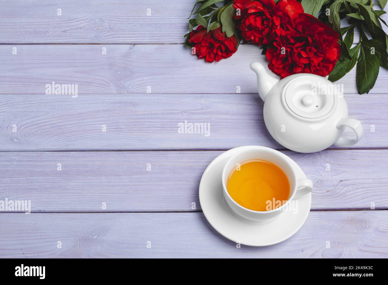 Cup of green tea on table with fresh peony flowers Stock Photo - Alamy