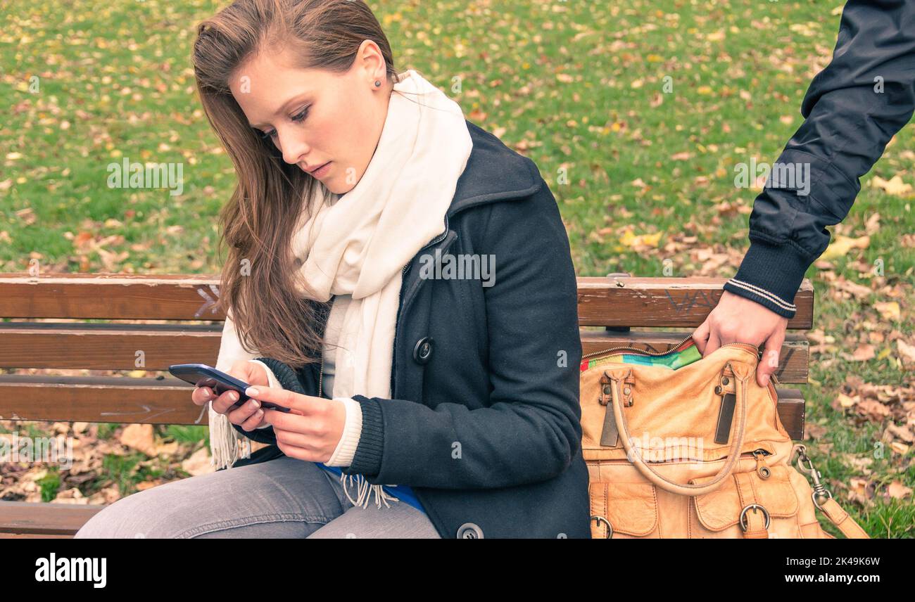 Pickpocketing from the bag of a young woman in a park Stock Photo - Alamy