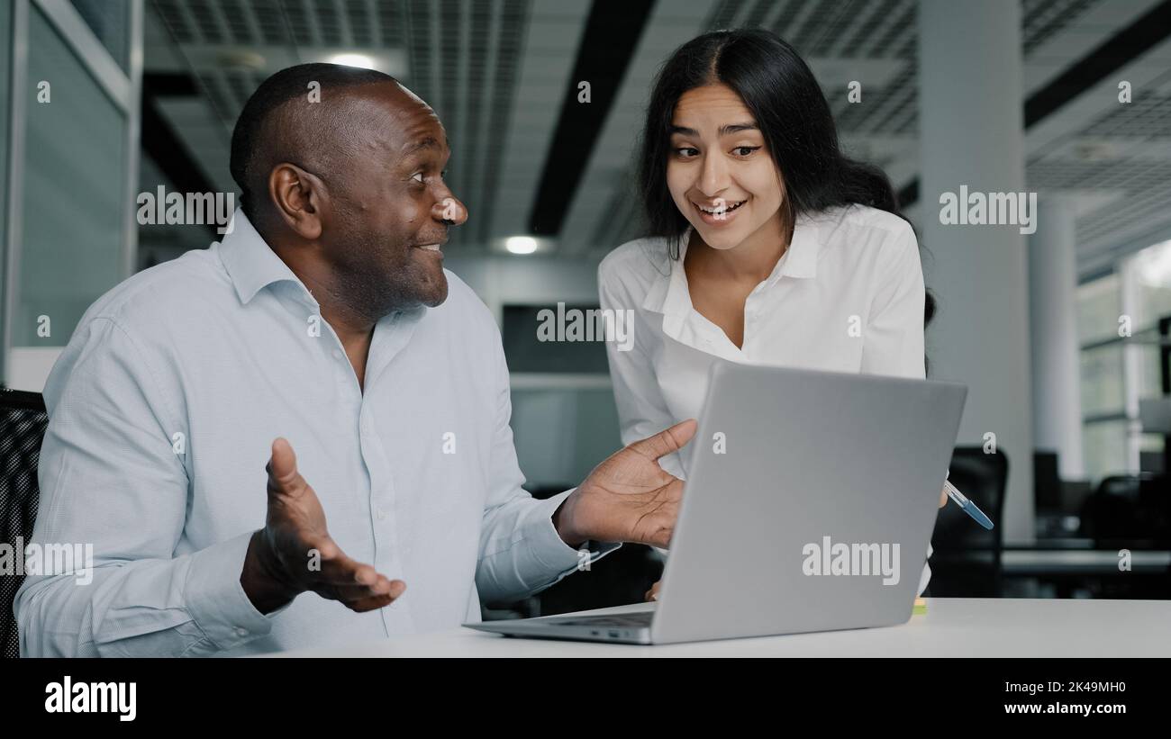 Arabian female leader instructor help african man colleague with ...