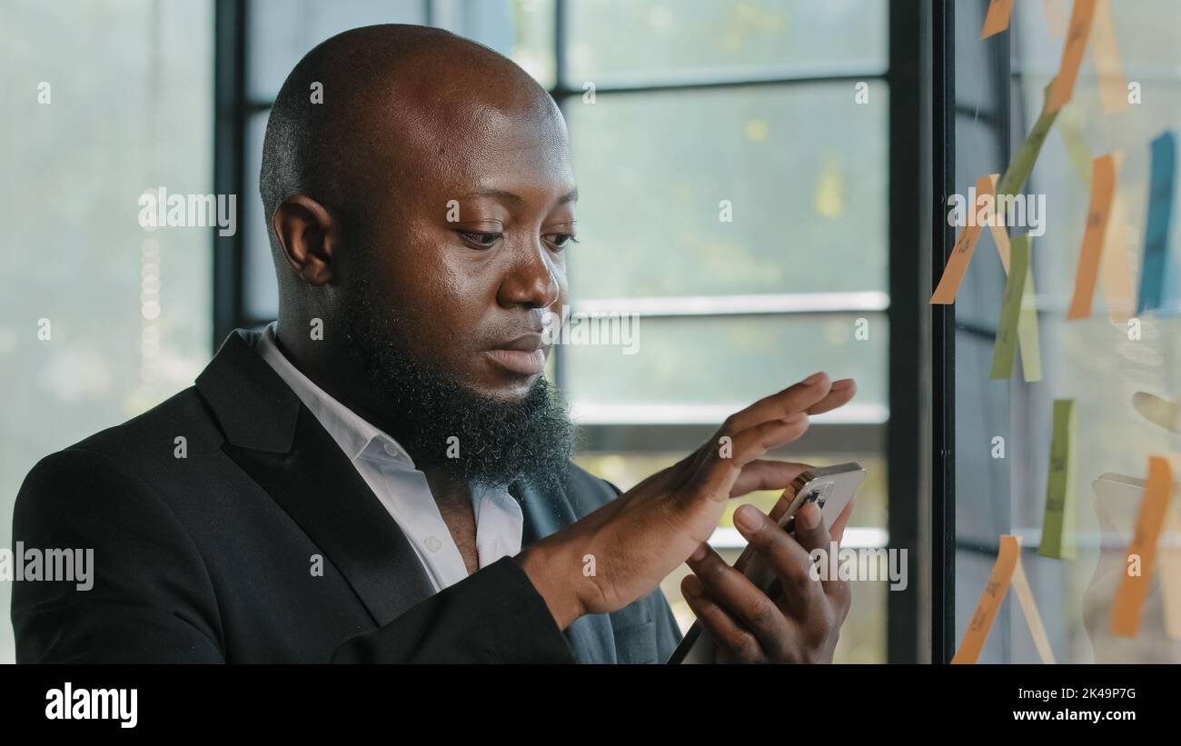 African american businessman stand near sticker board read news on ...