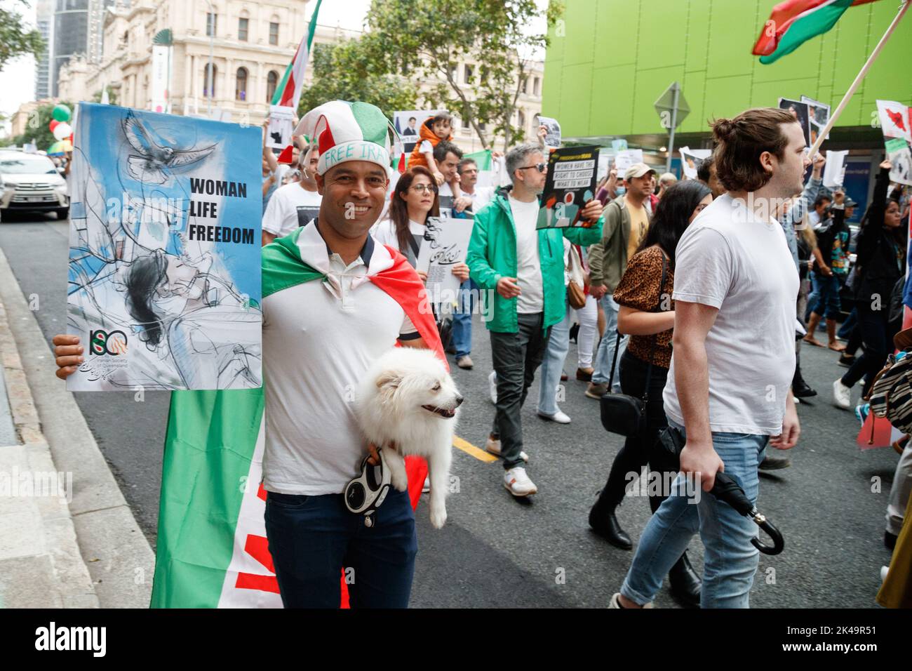 A man displays a placard as he carries his dog during a rally calling ...