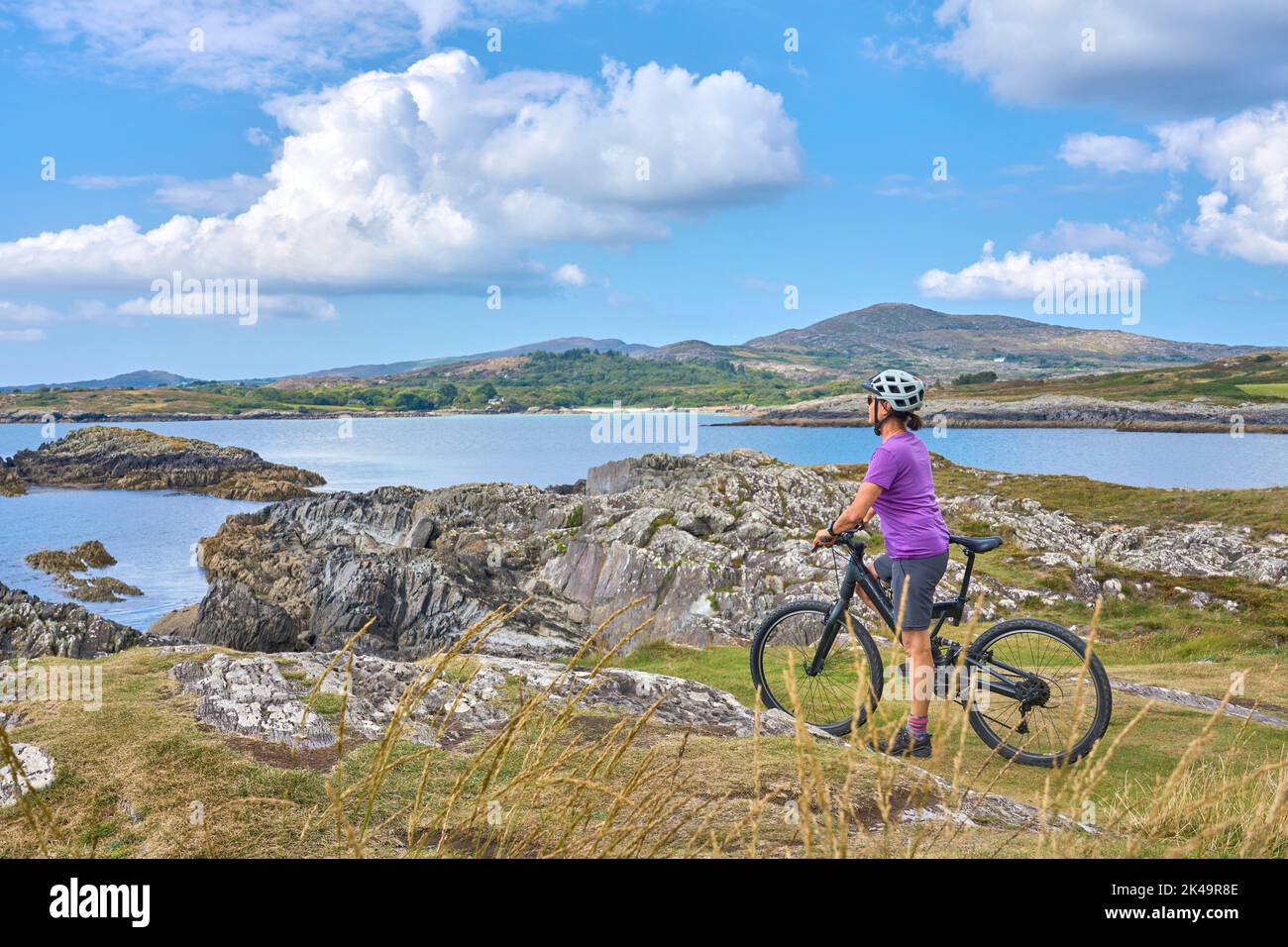nice senior woman on mountain bike, cycling on the cliffs of Toormore ...