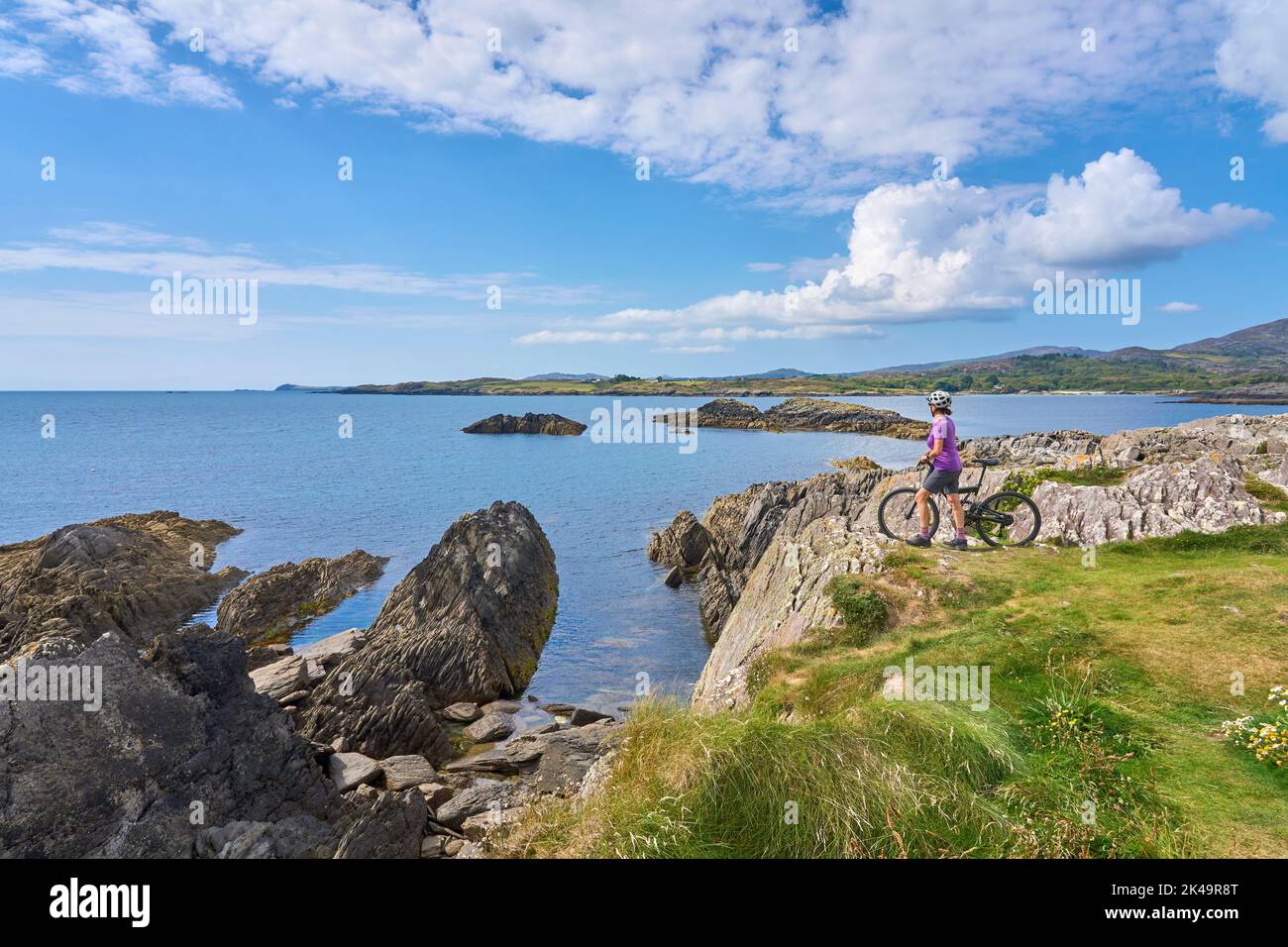 nice senior woman on mountain bike, cycling on the cliffs of Toormore ...