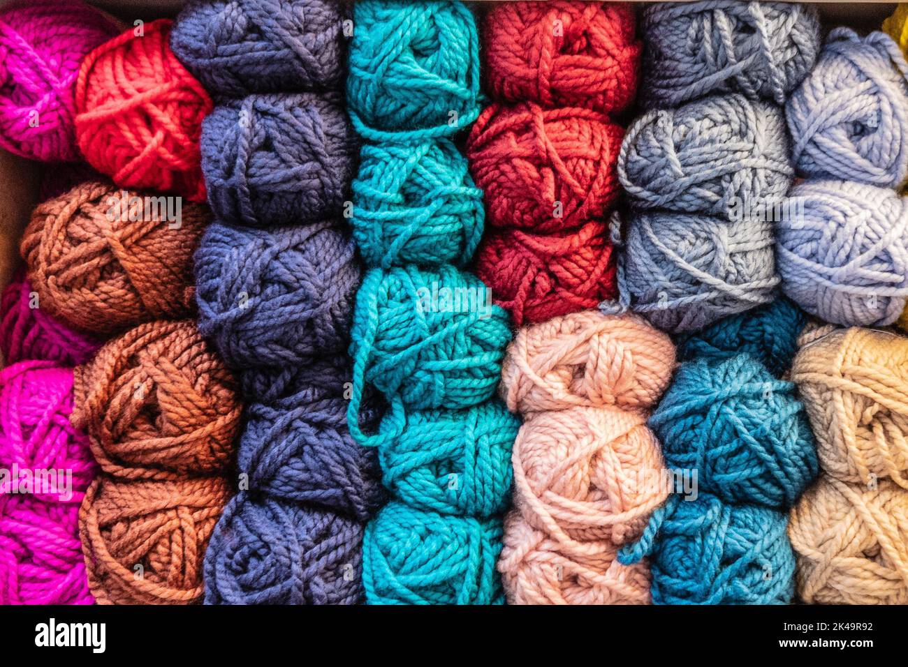 Coloured Balls of wool stacked on a shelf Stock Photo - Alamy