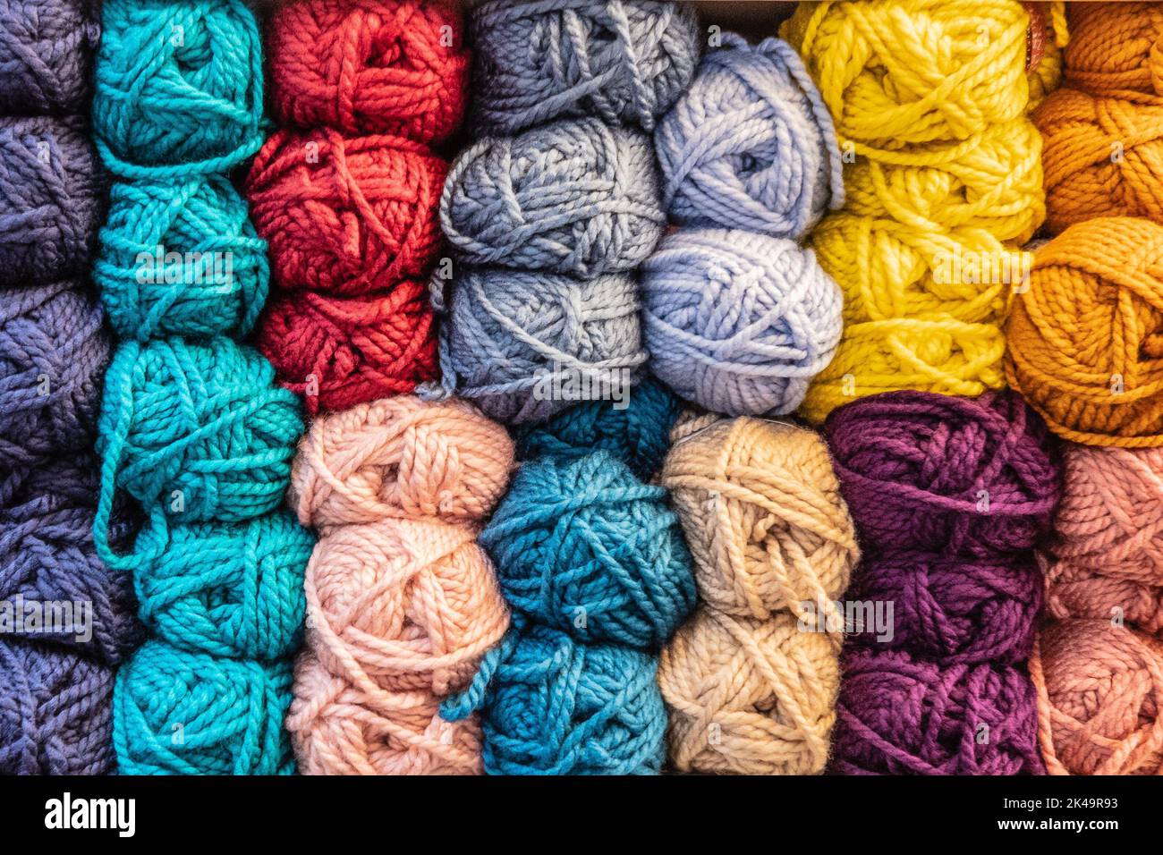 Coloured Balls of wool stacked on a shelf Stock Photo - Alamy