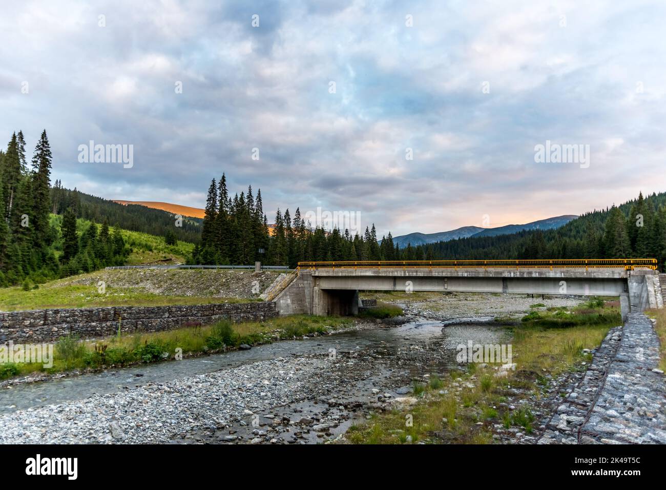 A bridge over a river with the Carpathian Mountains in the background ...