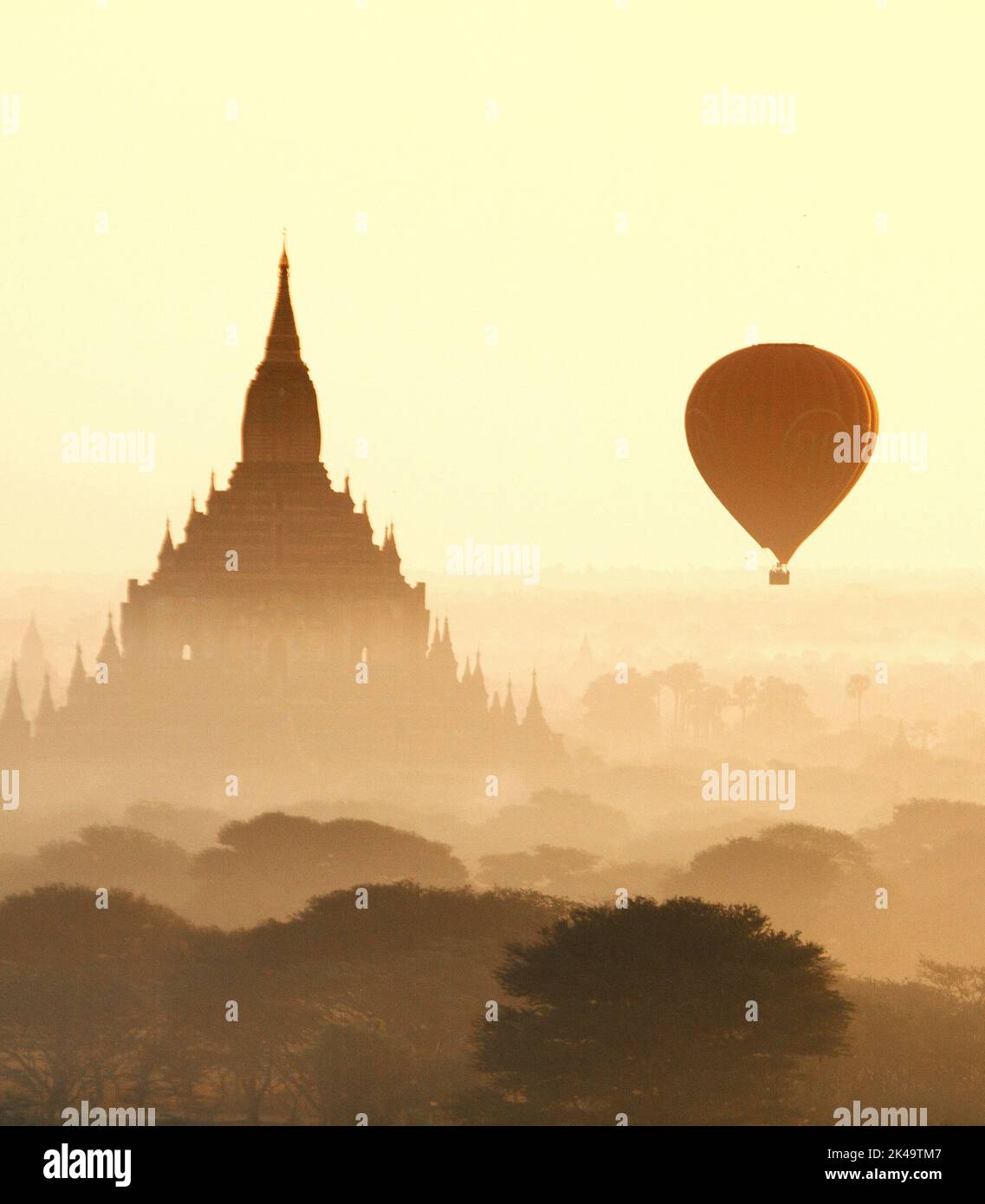 The scenic view of a balloon flying at the old Bagan temples of Myanmar ...