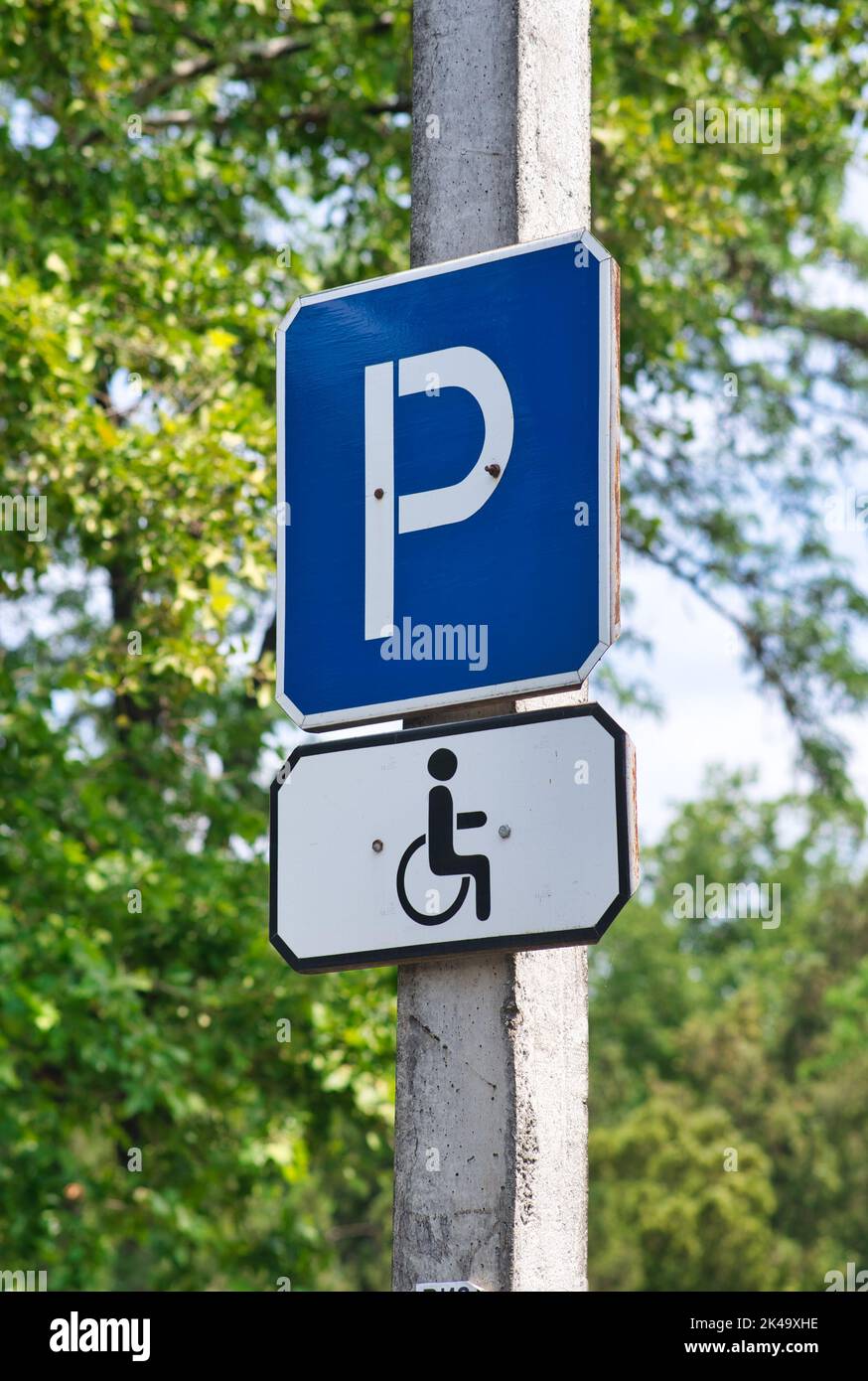 A vertical shot of a metal pole with a blue parking sign designated for ...