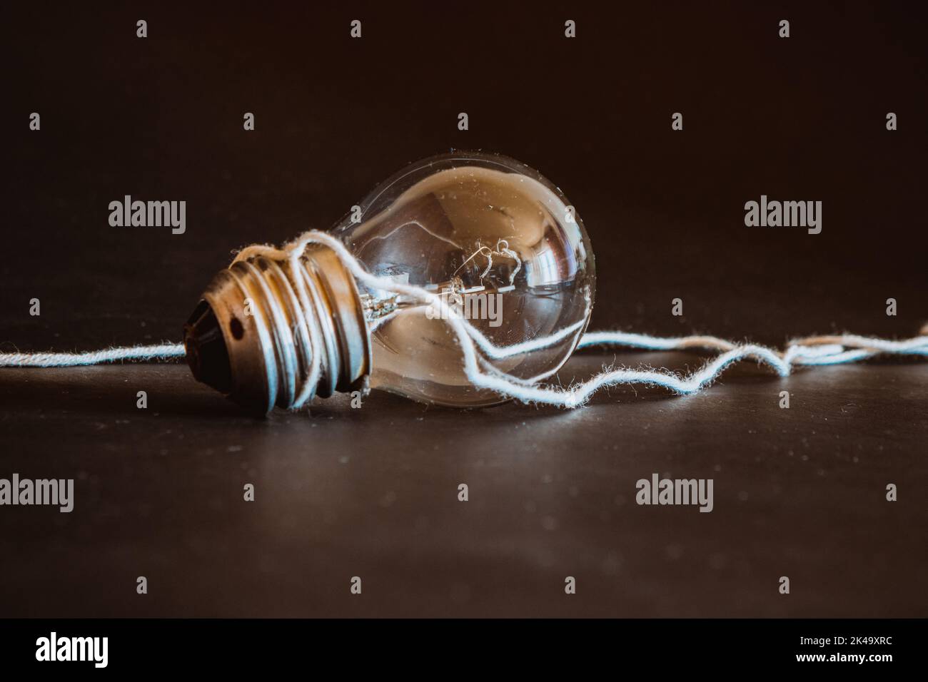 Concept crisis of electricity, electric light bulb tied with thread on ...