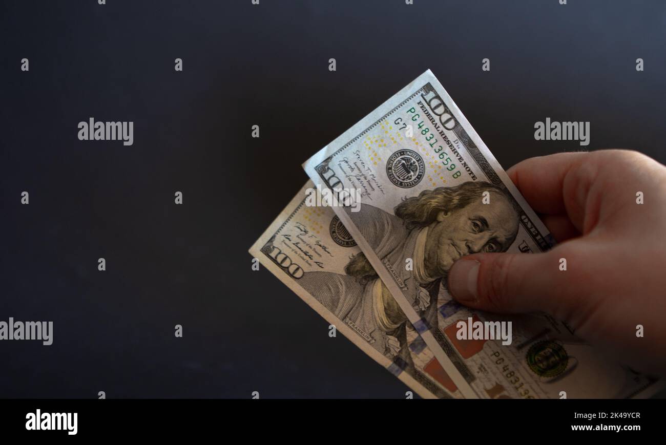 Right Hand Holds Stack of 100 Dollars Banknotes on black background ... Right Hand Holds Stack of 100 Dollars Banknotes on black background ...