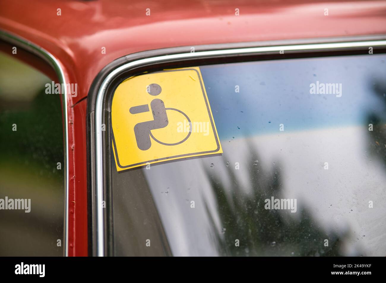 A yellow sign indicating a disabled driver at the car Stock Photo - Alamy