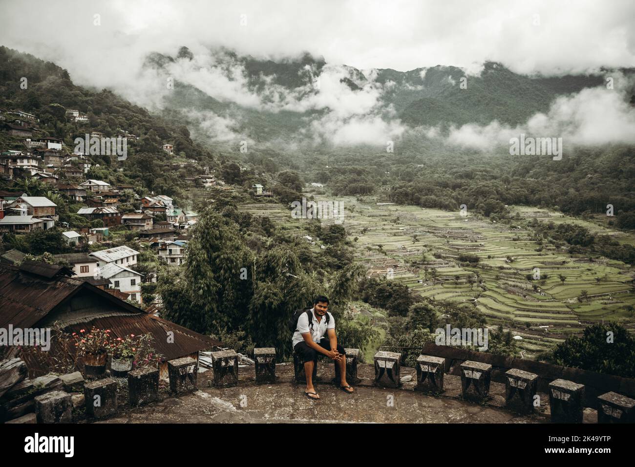 A male sitting and enjoying the view of the Khonoma village in Nagaland ...