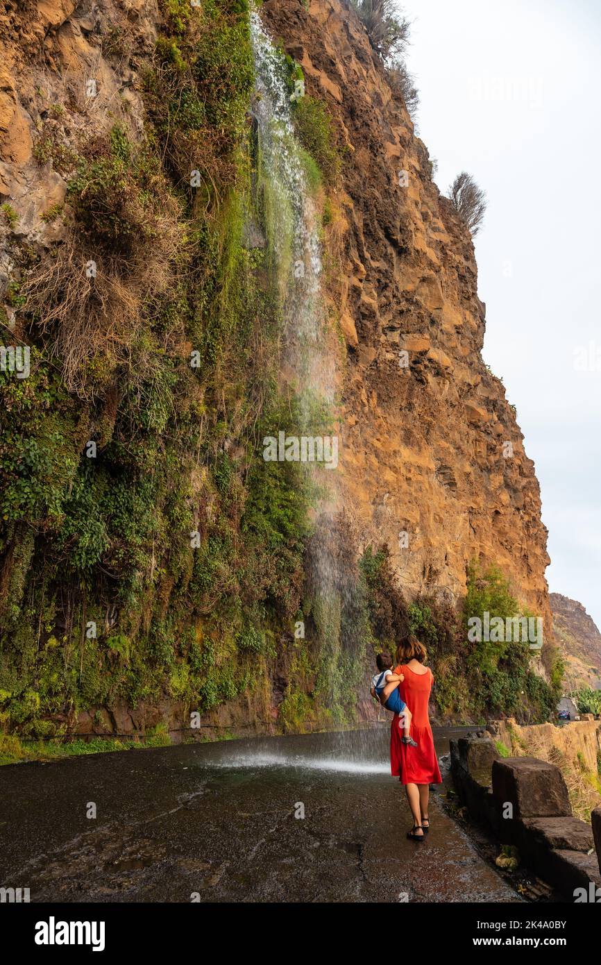 A vertical of a mother with her son at the Anjos waterfall that falls ...