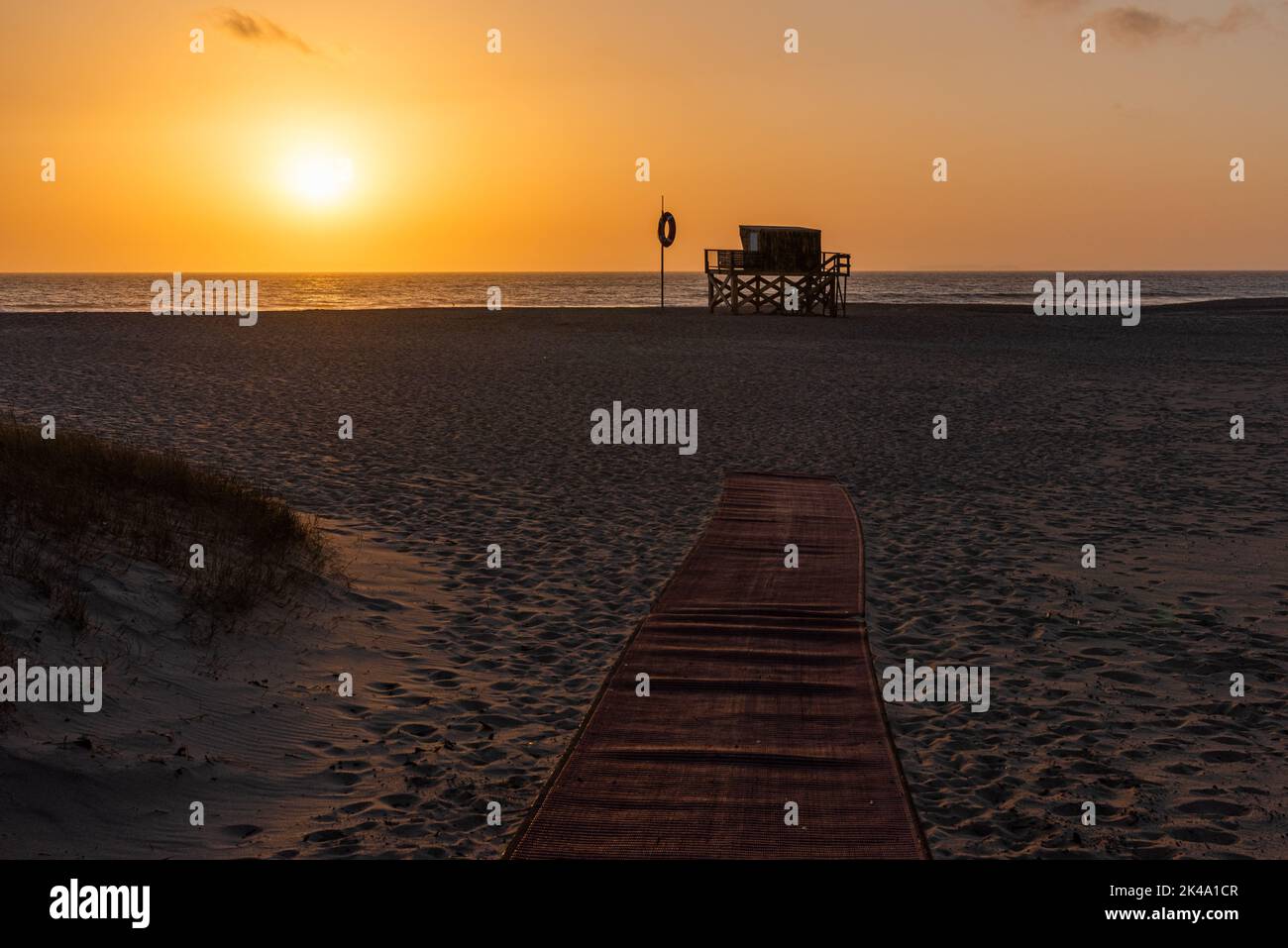 A scenic golden sunset at Areia Branca Beach in Lourinha, Portugal ...